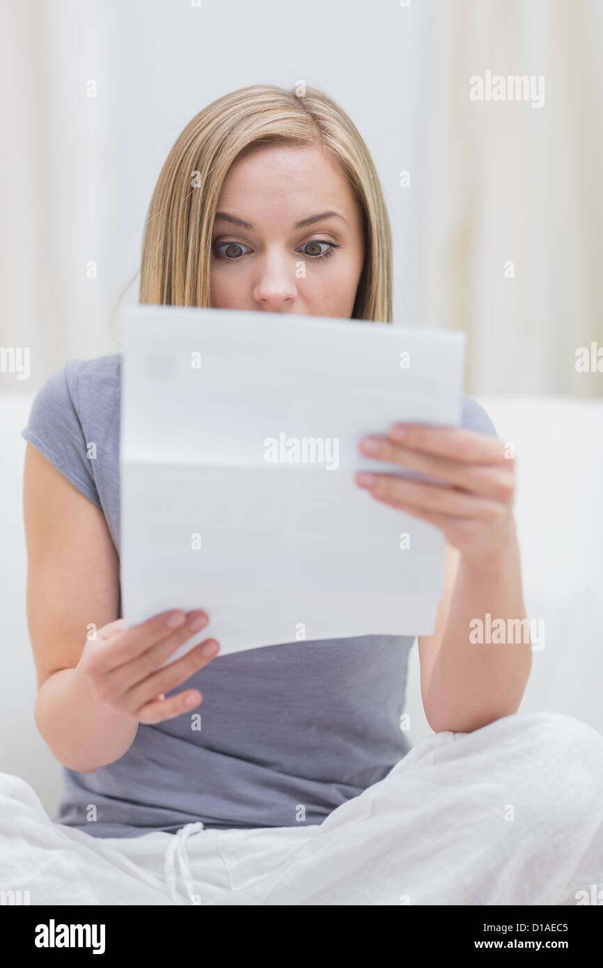 Casual woman reading letter in living room Stock Photo - Alamy