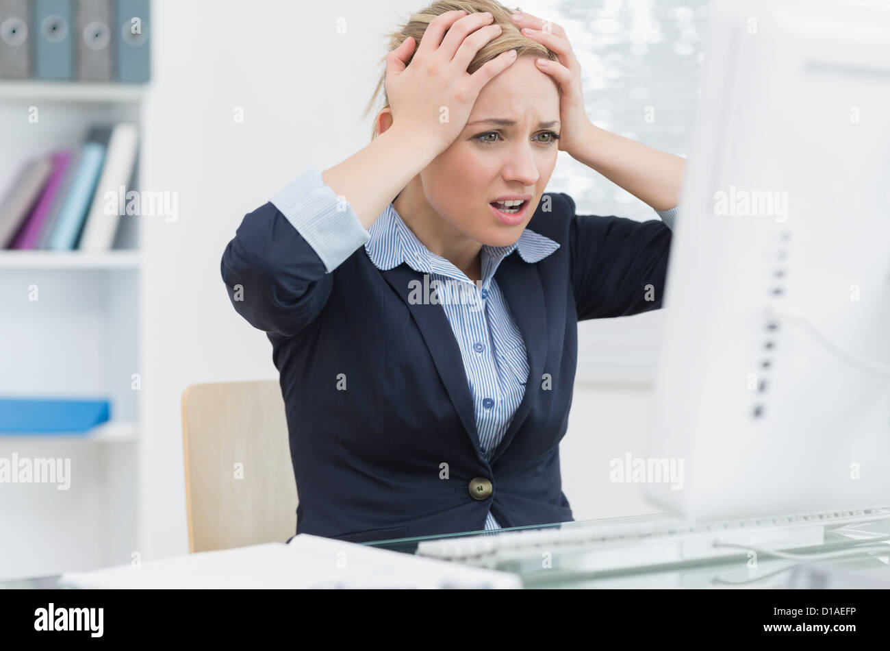 Frustrated business woman in front of computer at office desk Stock ...
