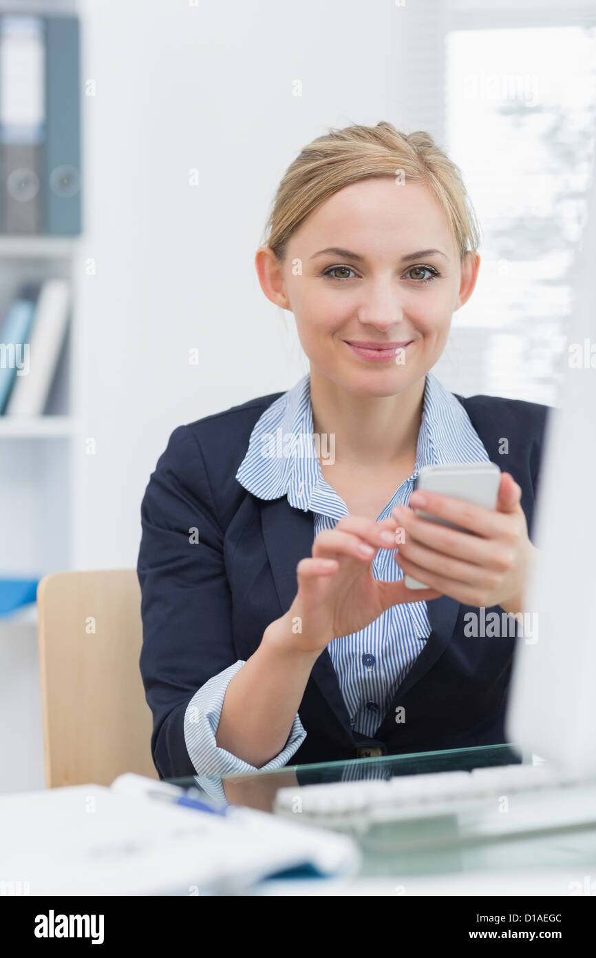 Portrait of business woman text messaging at office desk Stock Photo ...