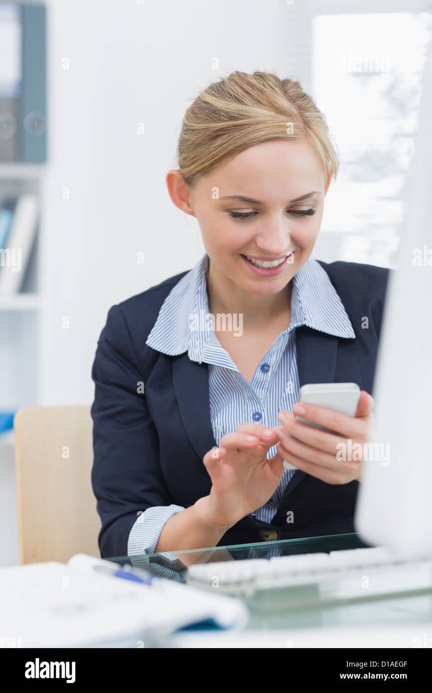 Young business woman text messaging at office desk Stock Photo - Alamy