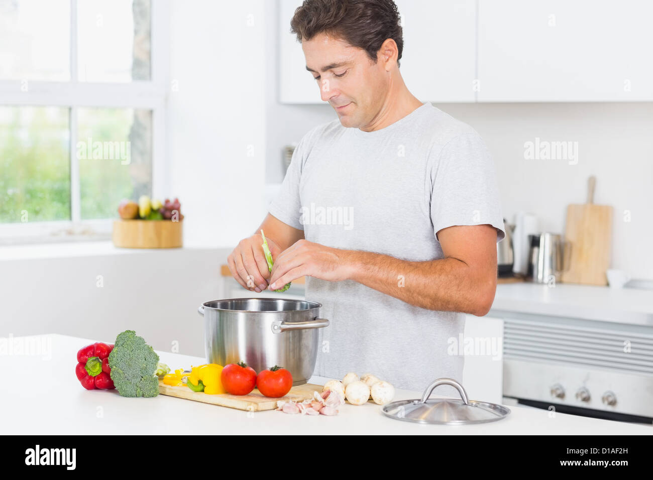 Happy man making dinner Stock Photo - Alamy