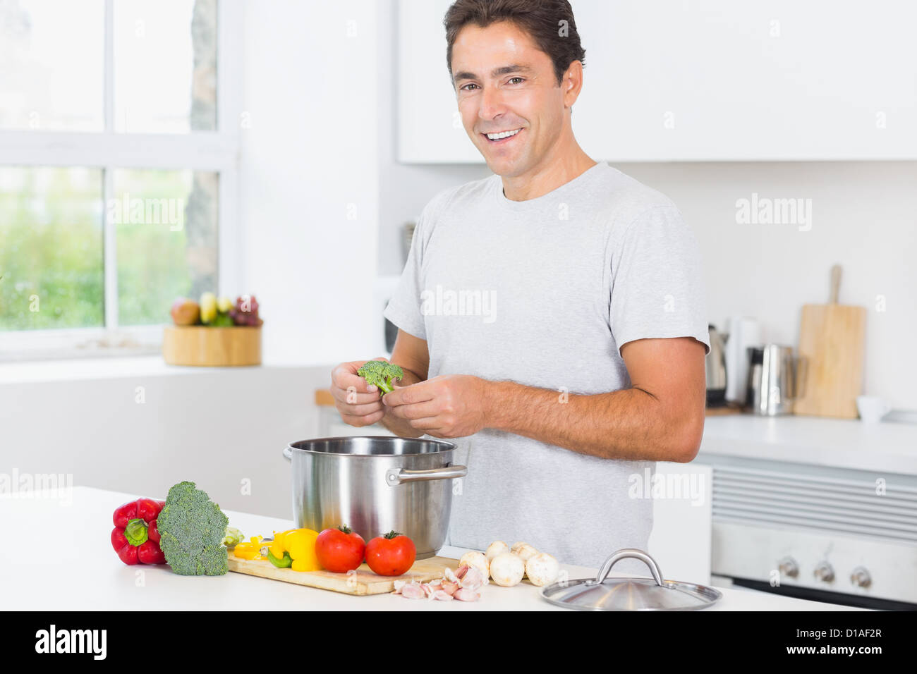 Smiling man making dinner Stock Photo - Alamy