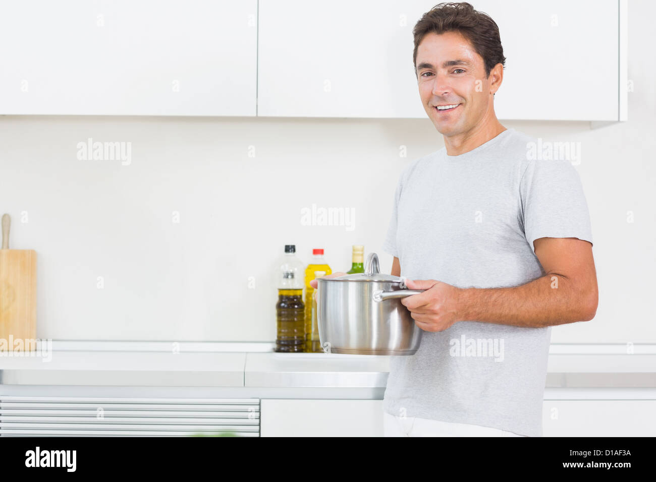 Handsome man carrying large pot Stock Photo - Alamy