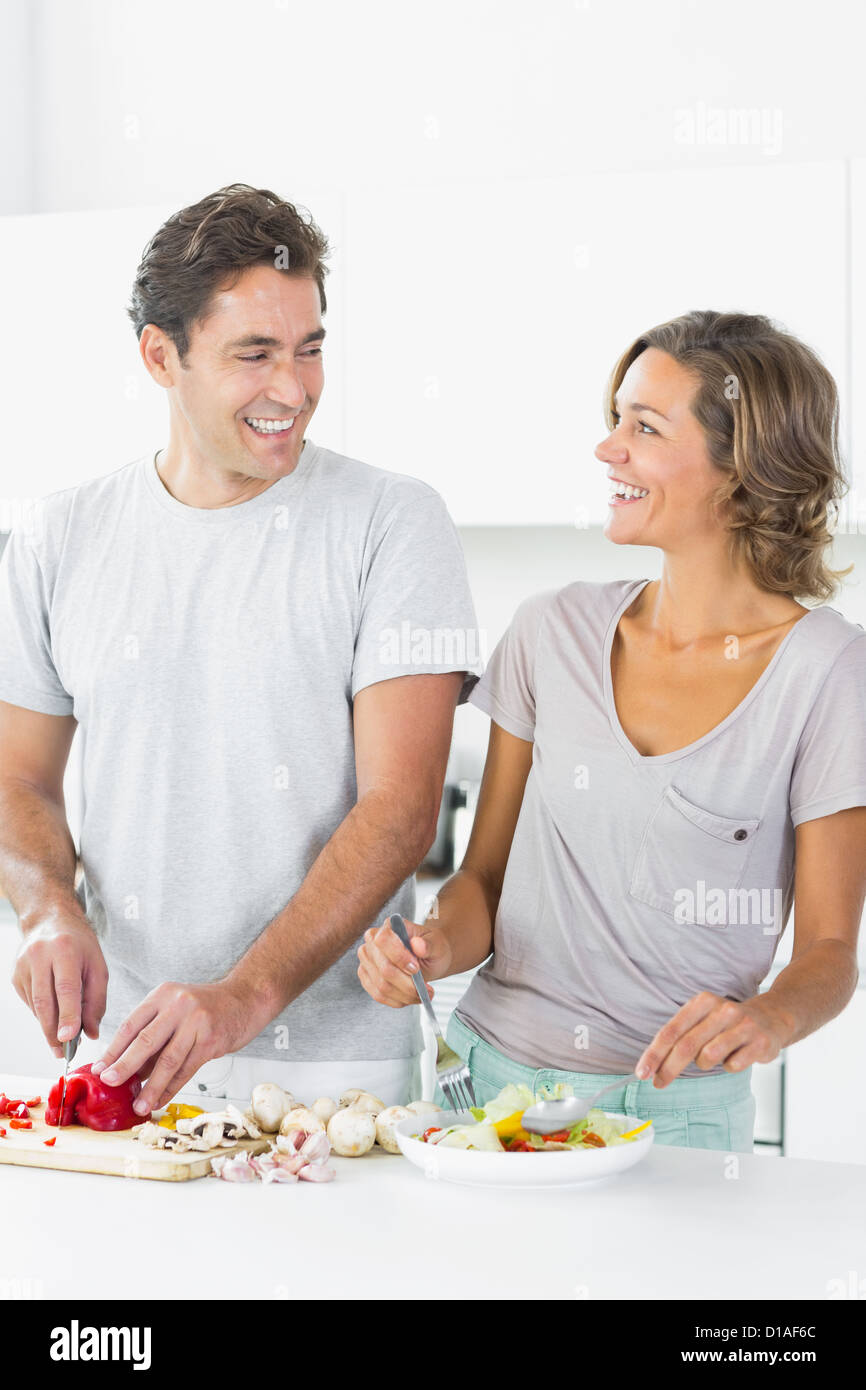 Smiling couple making salad together Stock Photo - Alamy