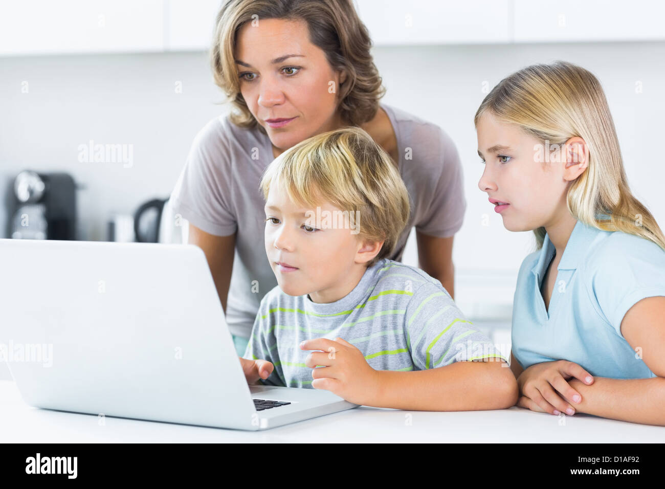 Mother and children using laptop Stock Photo - Alamy