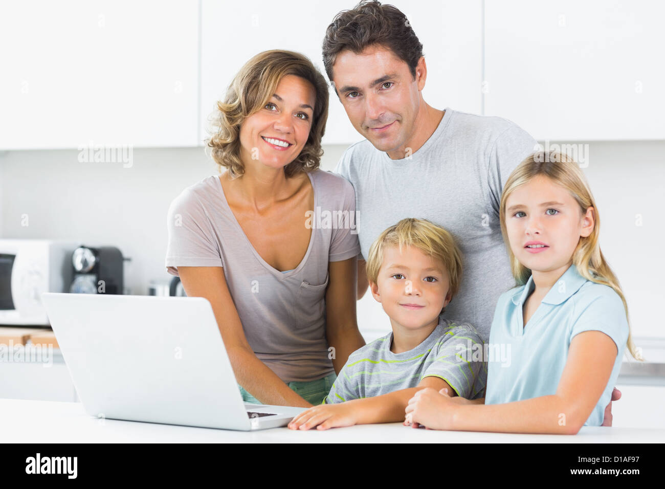 Smiling family with laptop Stock Photo - Alamy