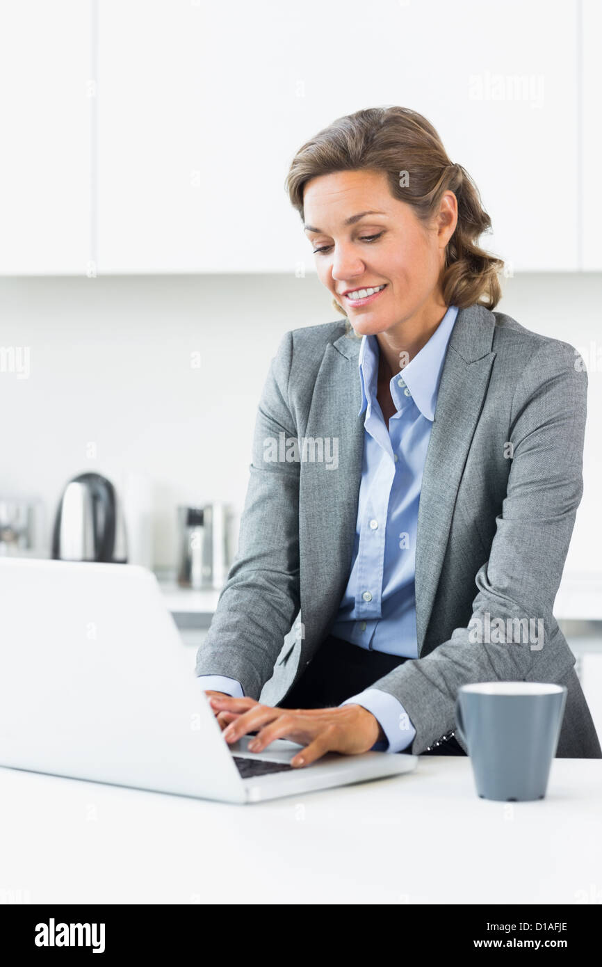 Happy woman typing on laptop Stock Photo - Alamy