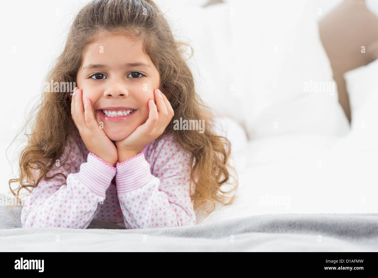 Cute girl lying on bed Stock Photo - Alamy