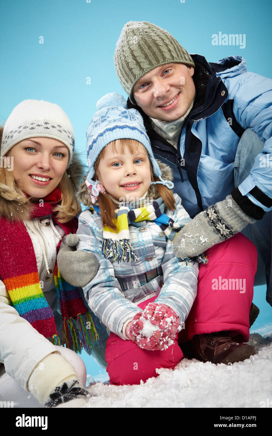 Happy parents and their daughter in winterwear looking at camera with ...