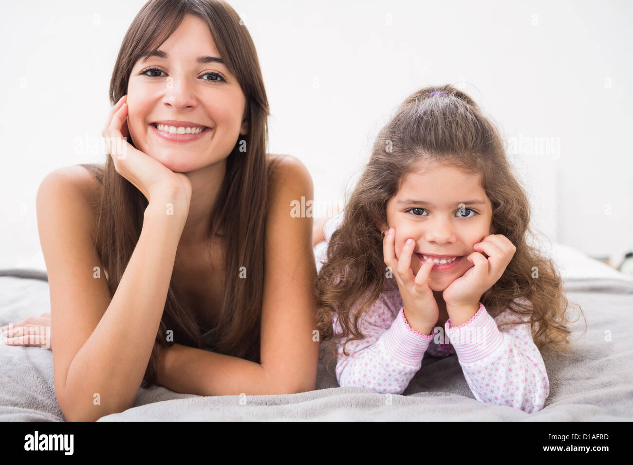 Mother and daughter smiling in bed Stock Photo - Alamy