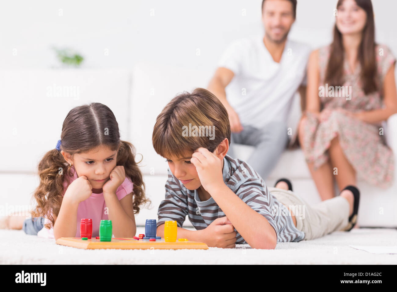 Siblings playing board game on the floor Stock Photo - Alamy