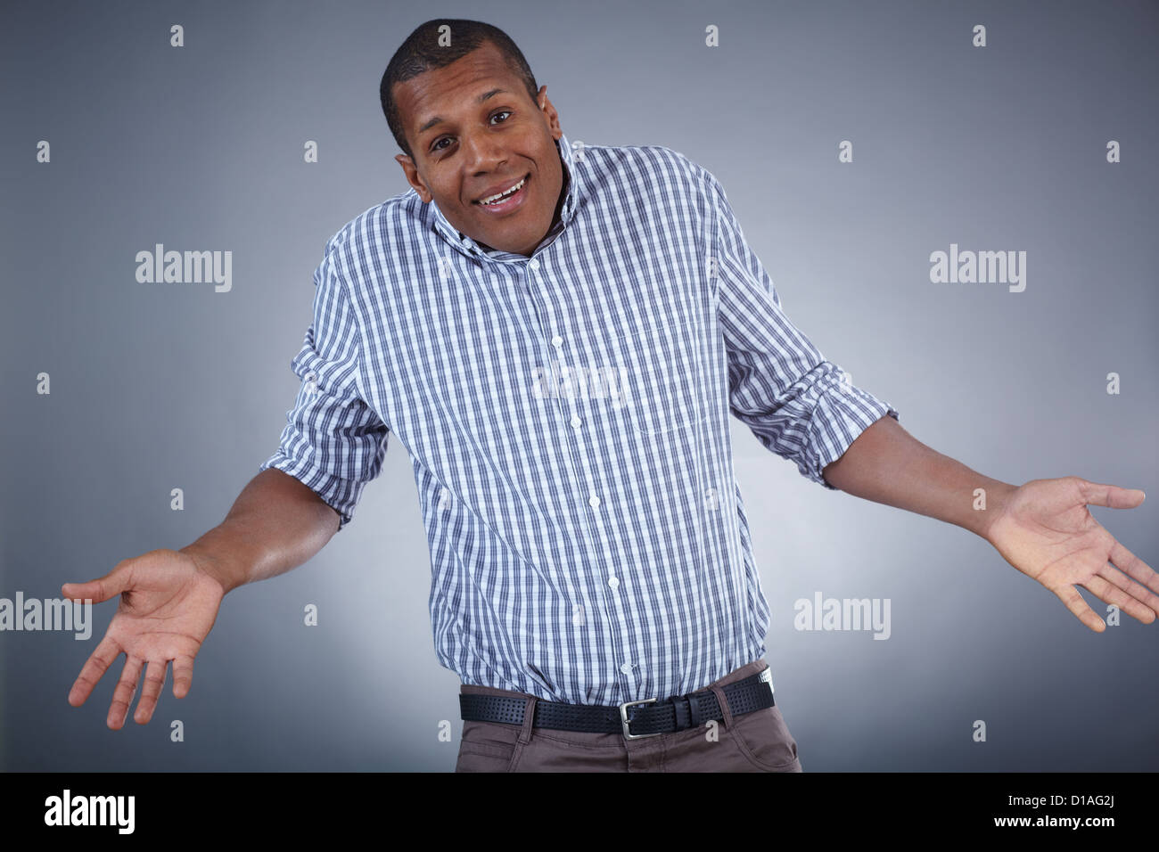 Image of young African man expressing uncertainty over grey background ...