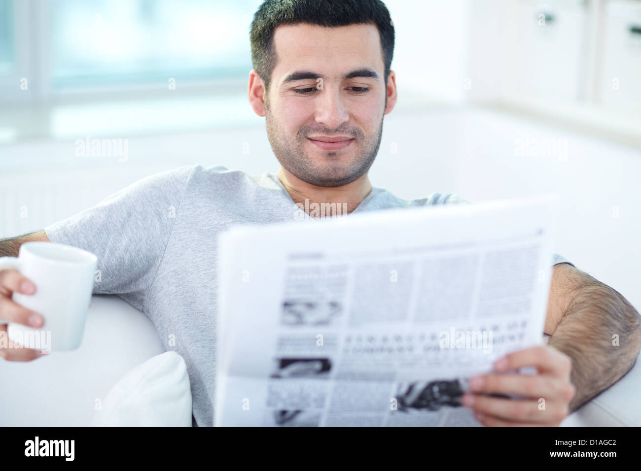 A young guy with newspaper reading it at home Stock Photo - Alamy