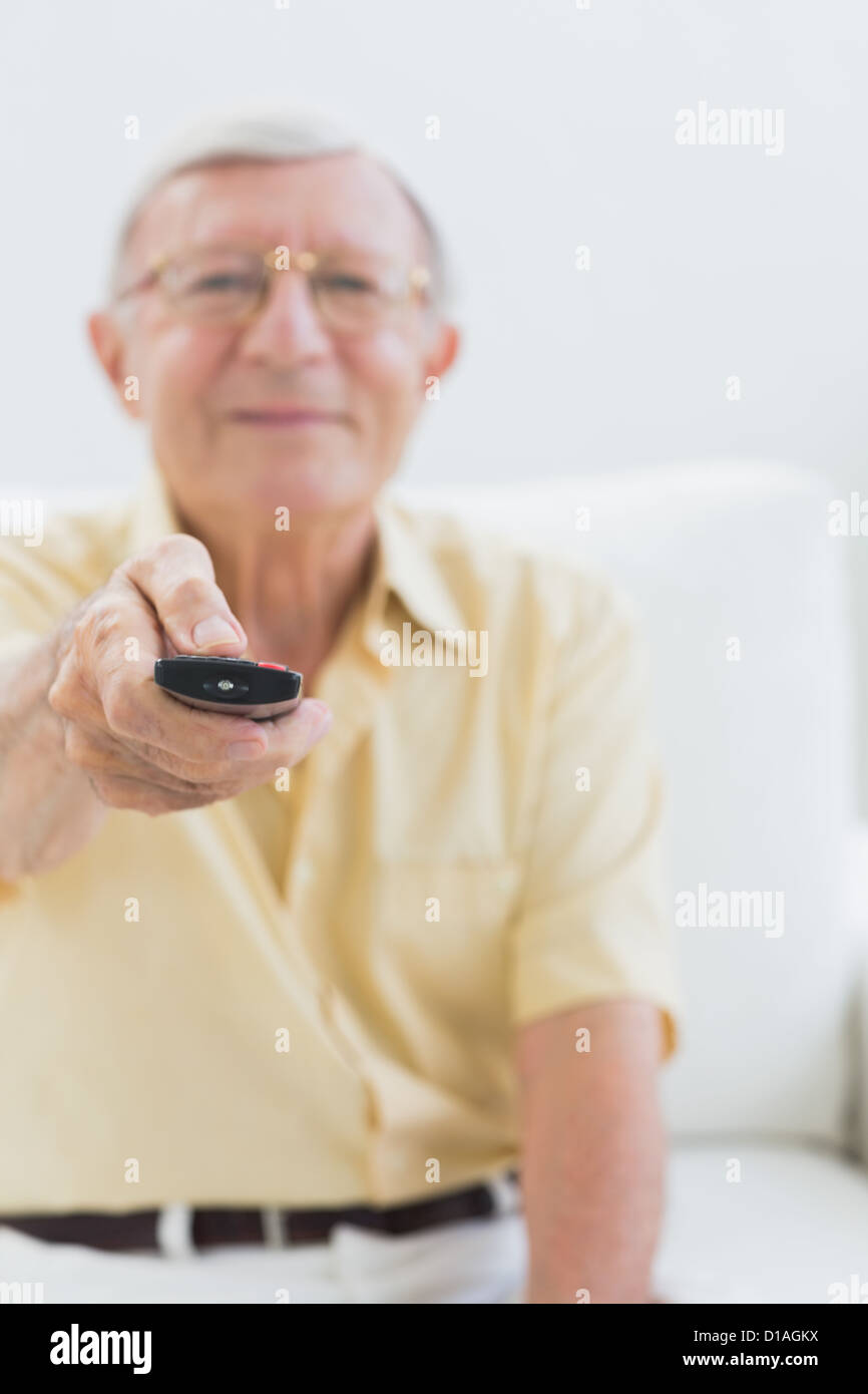 Cheerful elderly man using the remote Stock Photo - Alamy