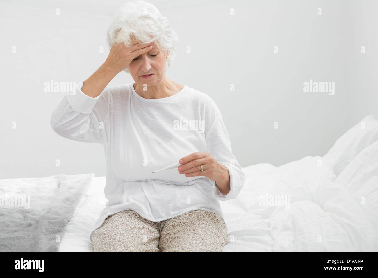 Aged woman suffering with fever Stock Photo - Alamy