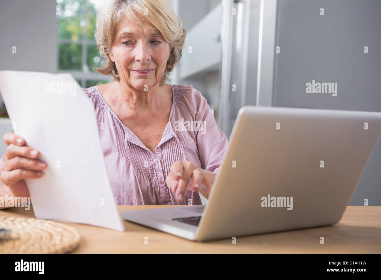 Stern mature woman using her laptop Stock Photo - Alamy