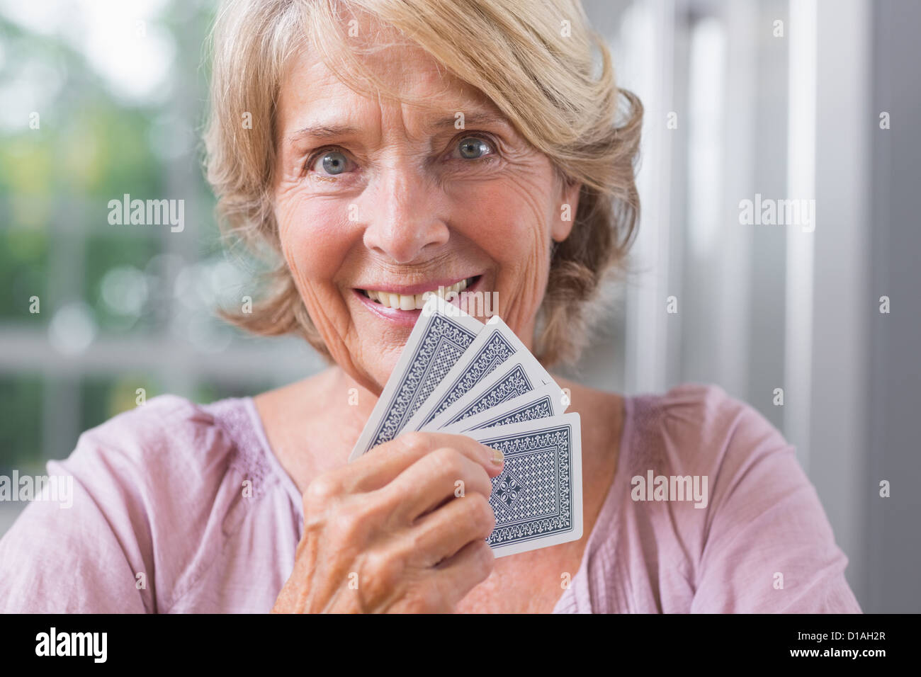Close up of a happy woman playing cards Stock Photo - Alamy