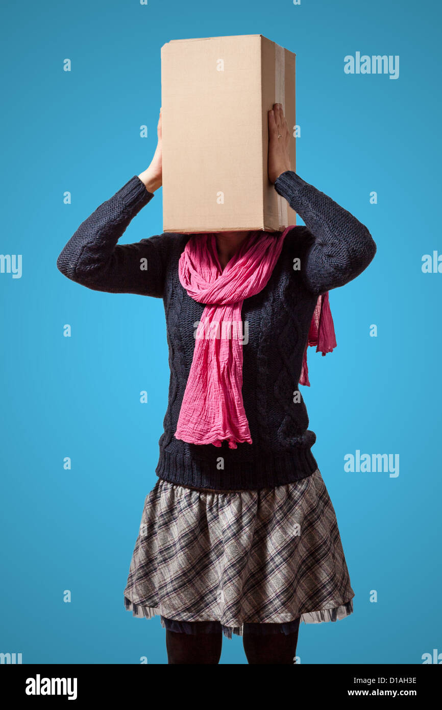 Girl holding her cardboard box head with hands on cyan background Stock ...