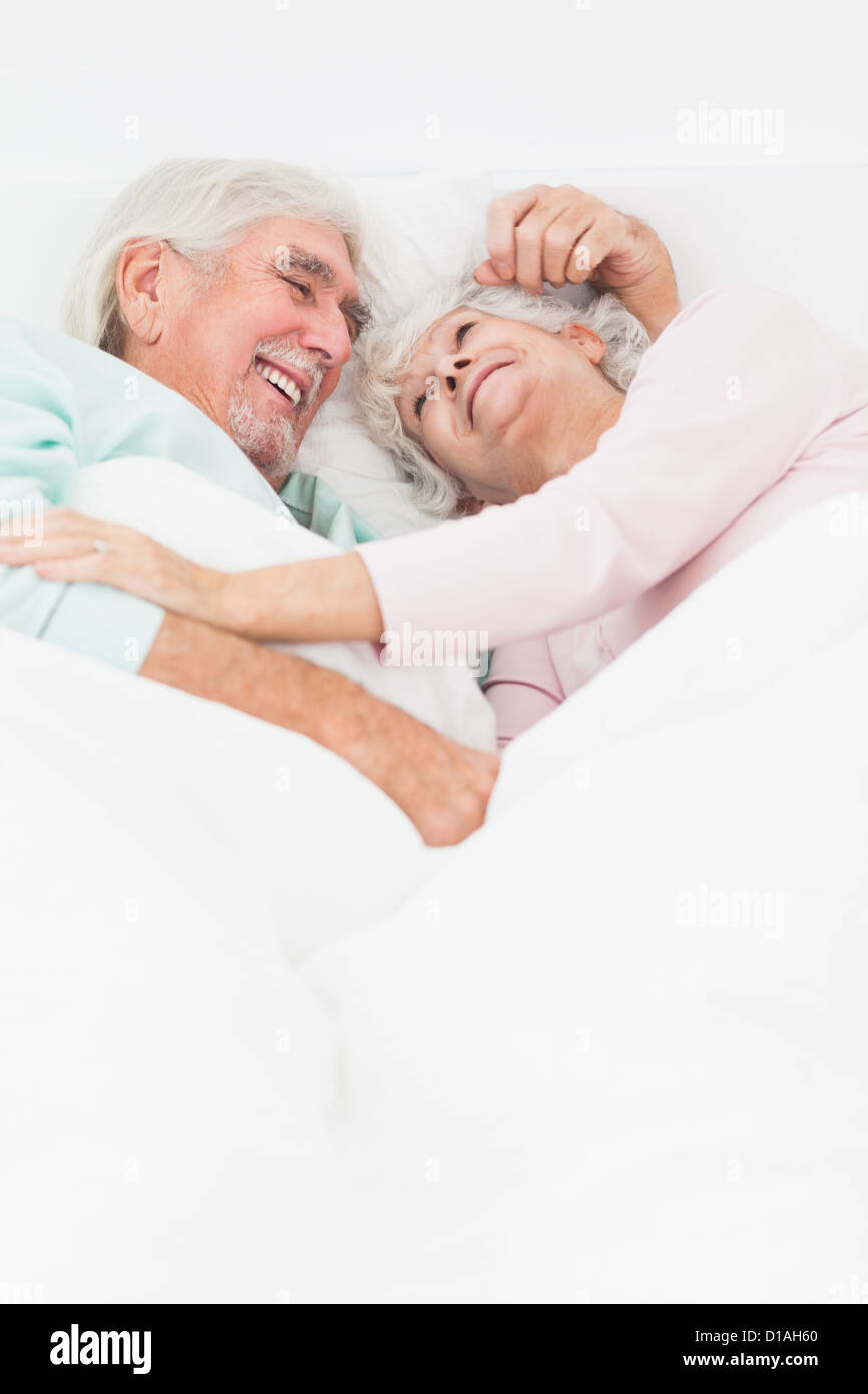 Couple embracing in bed Stock Photo - Alamy