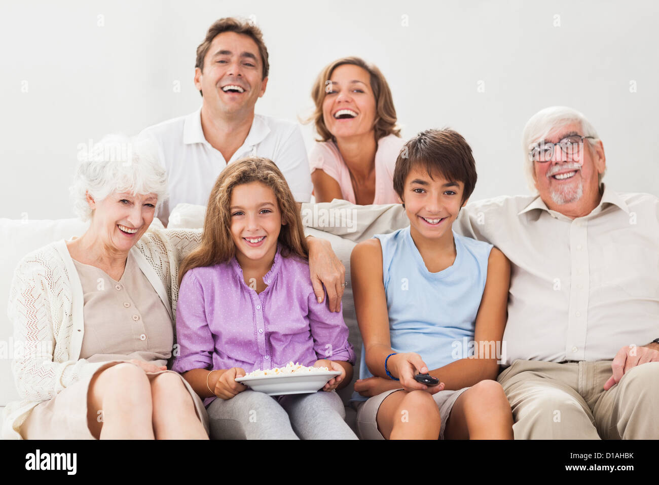 Multi-generation family on couch watching tv Stock Photo - Alamy