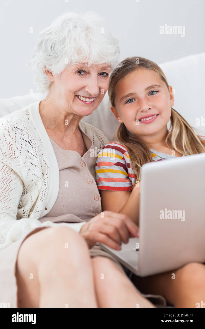 Happy girl using laptop with granny Stock Photo - Alamy