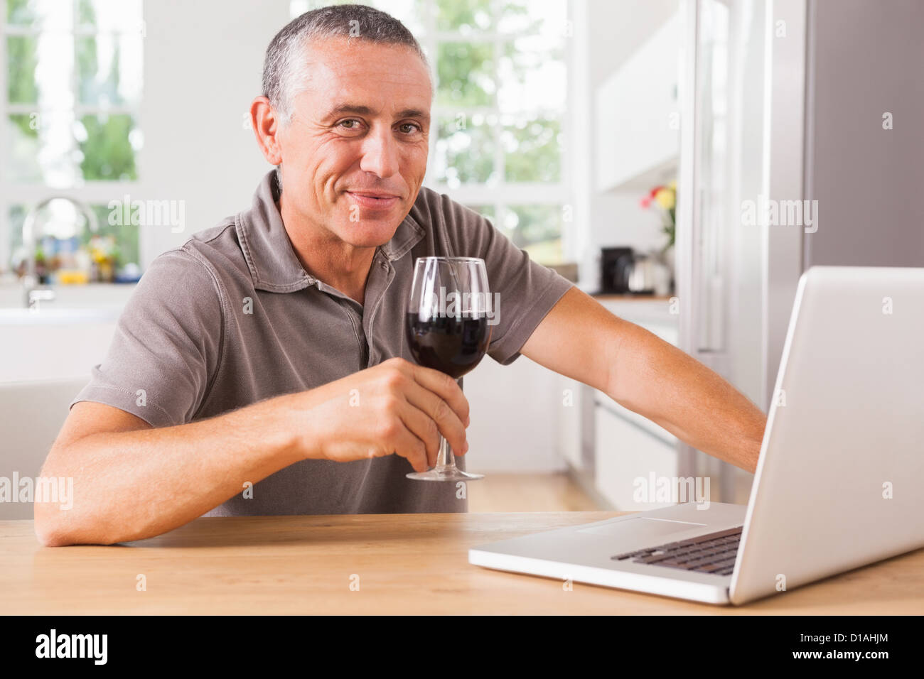 Happy man at kitchen table Stock Photo - Alamy