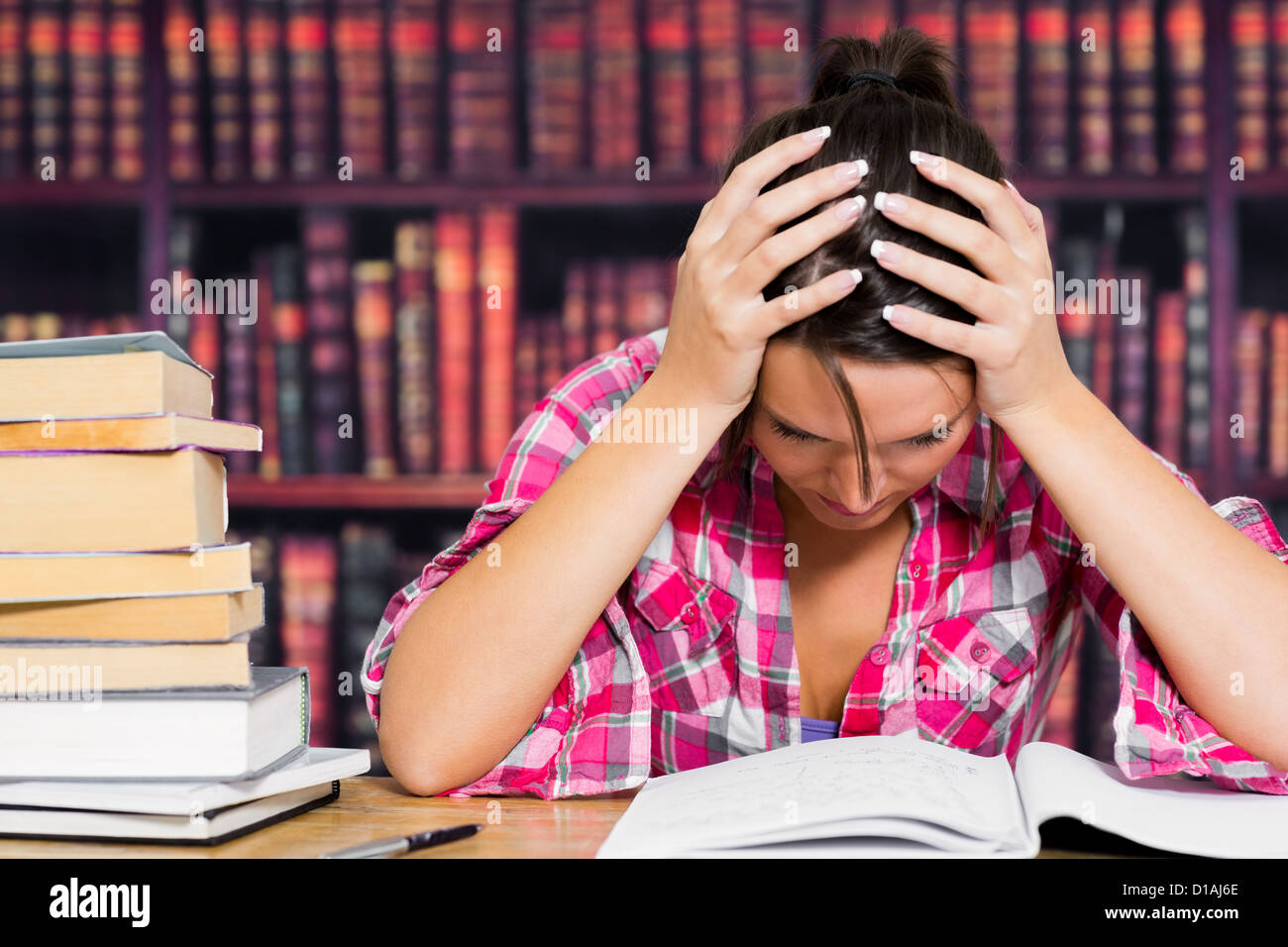 Stressed student in library Stock Photo - Alamy