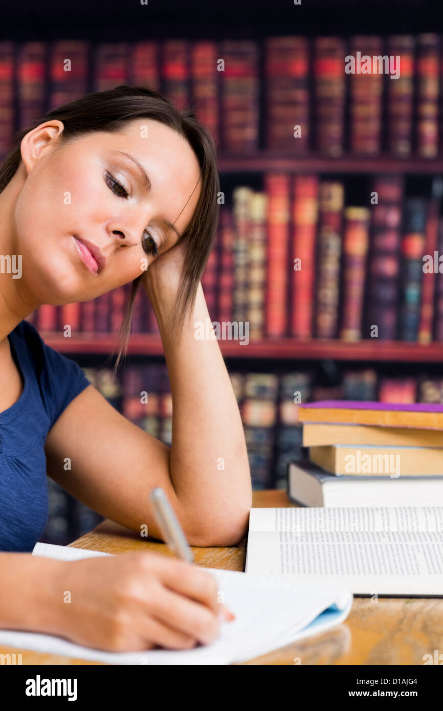 Cute girl writing with book Stock Photo - Alamy