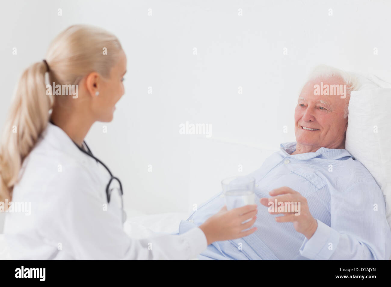 Doctor handing glass of water to patient Stock Photo - Alamy