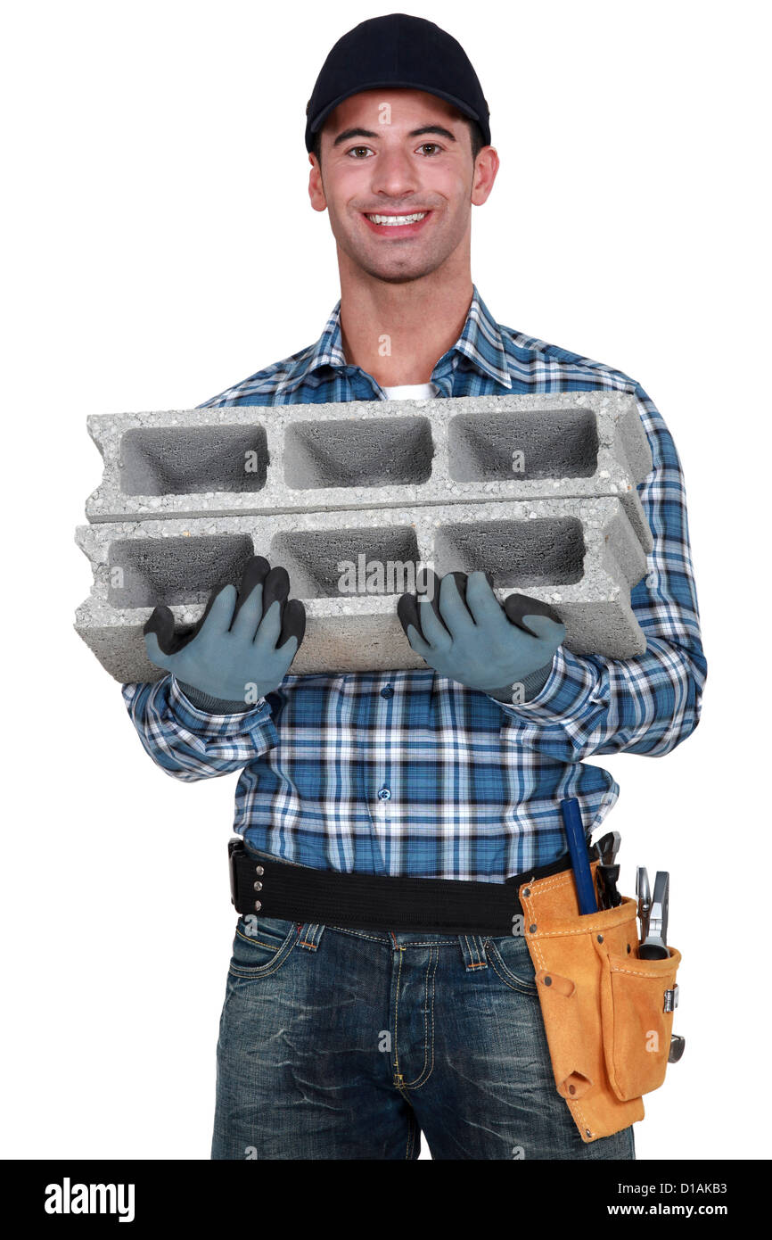 Mason carrying breeze block Stock Photo - Alamy