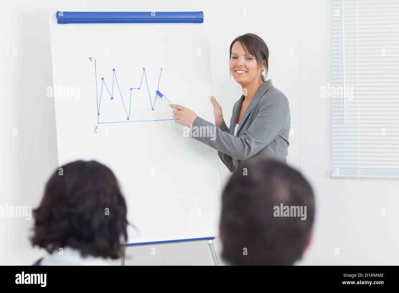 Businesswoman showing the graph with her pen Stock Photo - Alamy