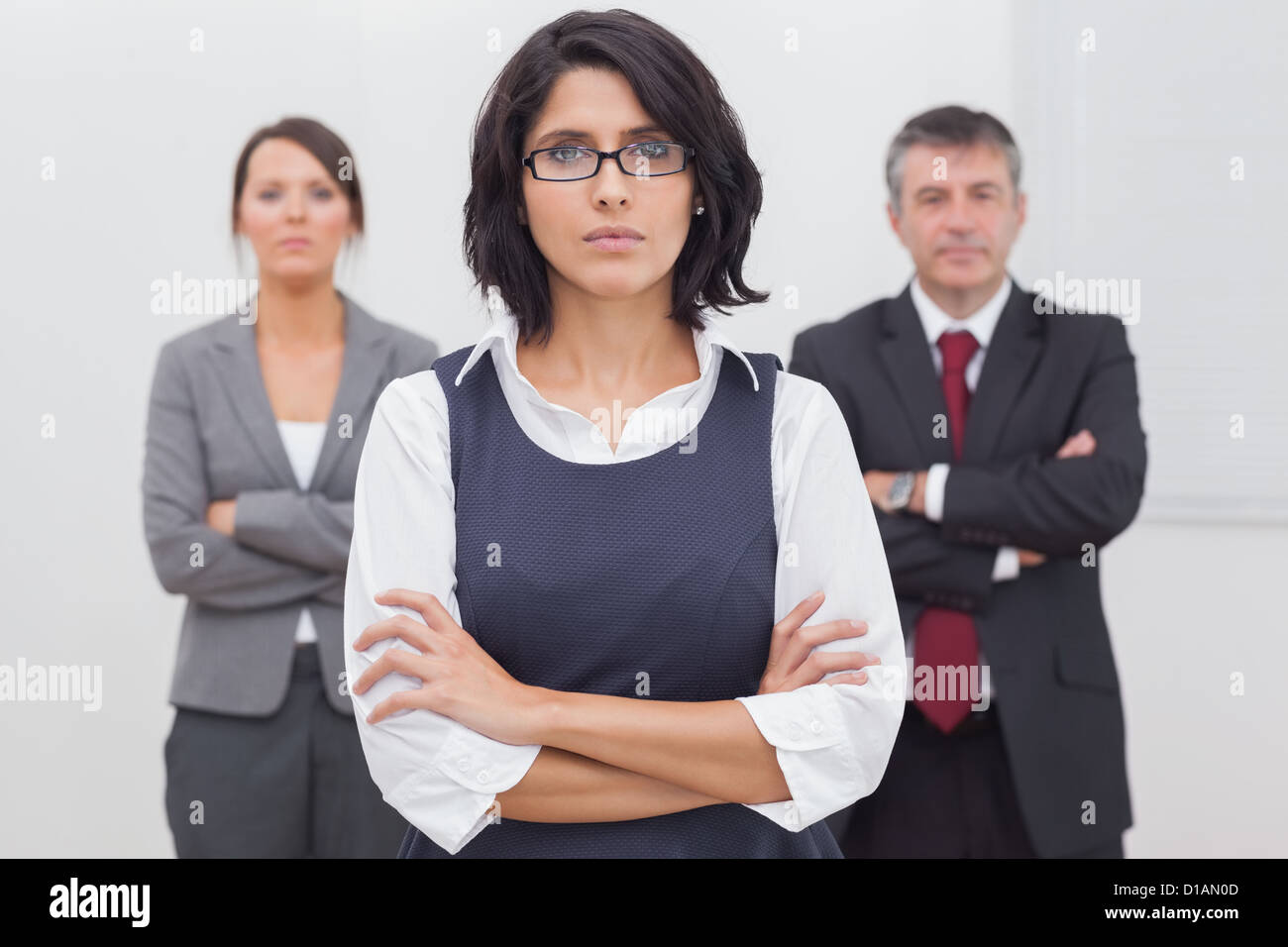 Three business people folding their arms seriously Stock Photo - Alamy