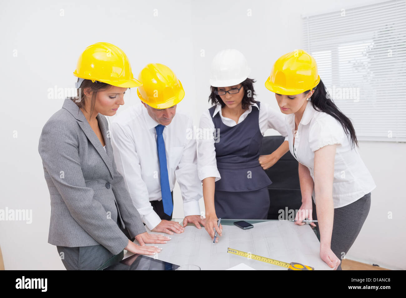 Team looking at a construction plan Stock Photo - Alamy