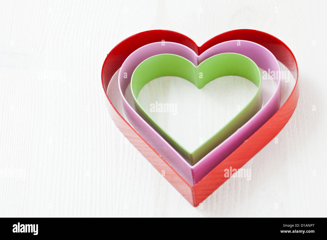 Colorful nested metal heart shapes on white background Stock Photo - Alamy