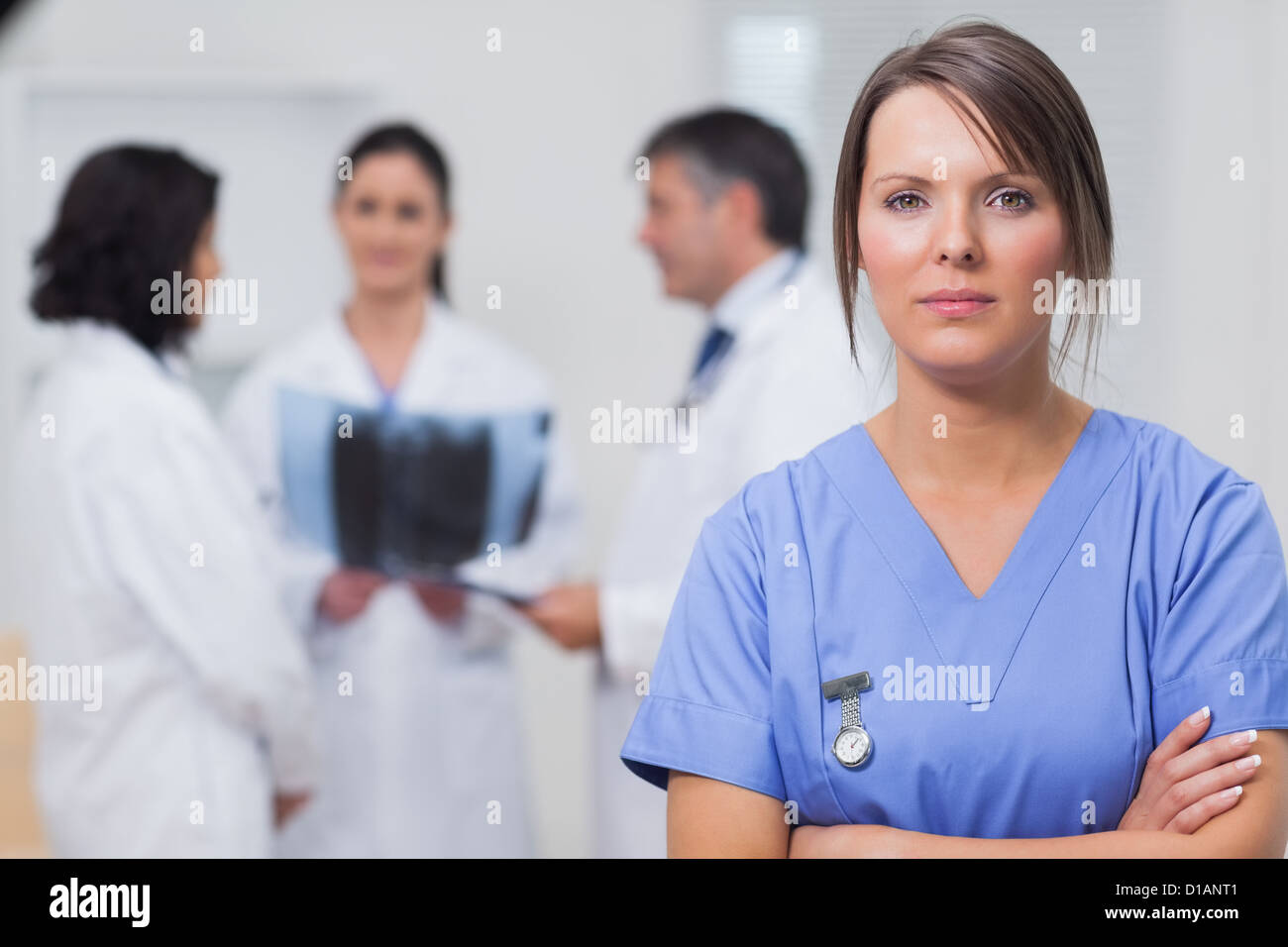 Nurse standing seriously with her team Stock Photo - Alamy