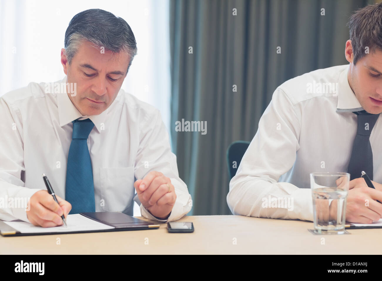 Businessmen taking notes Stock Photo - Alamy