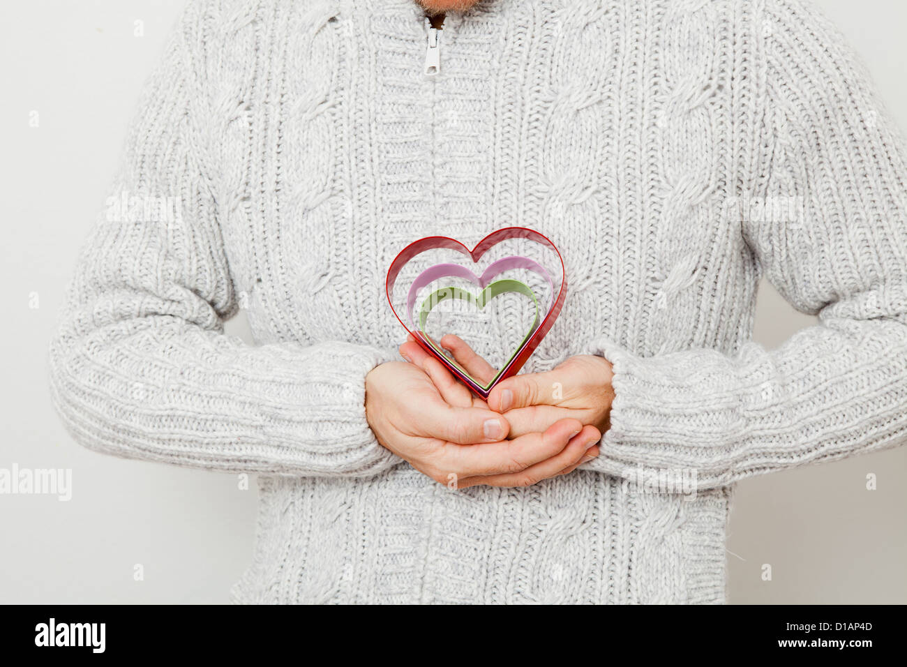 Three colored metal heart symbols held in the hands Stock Photo - Alamy