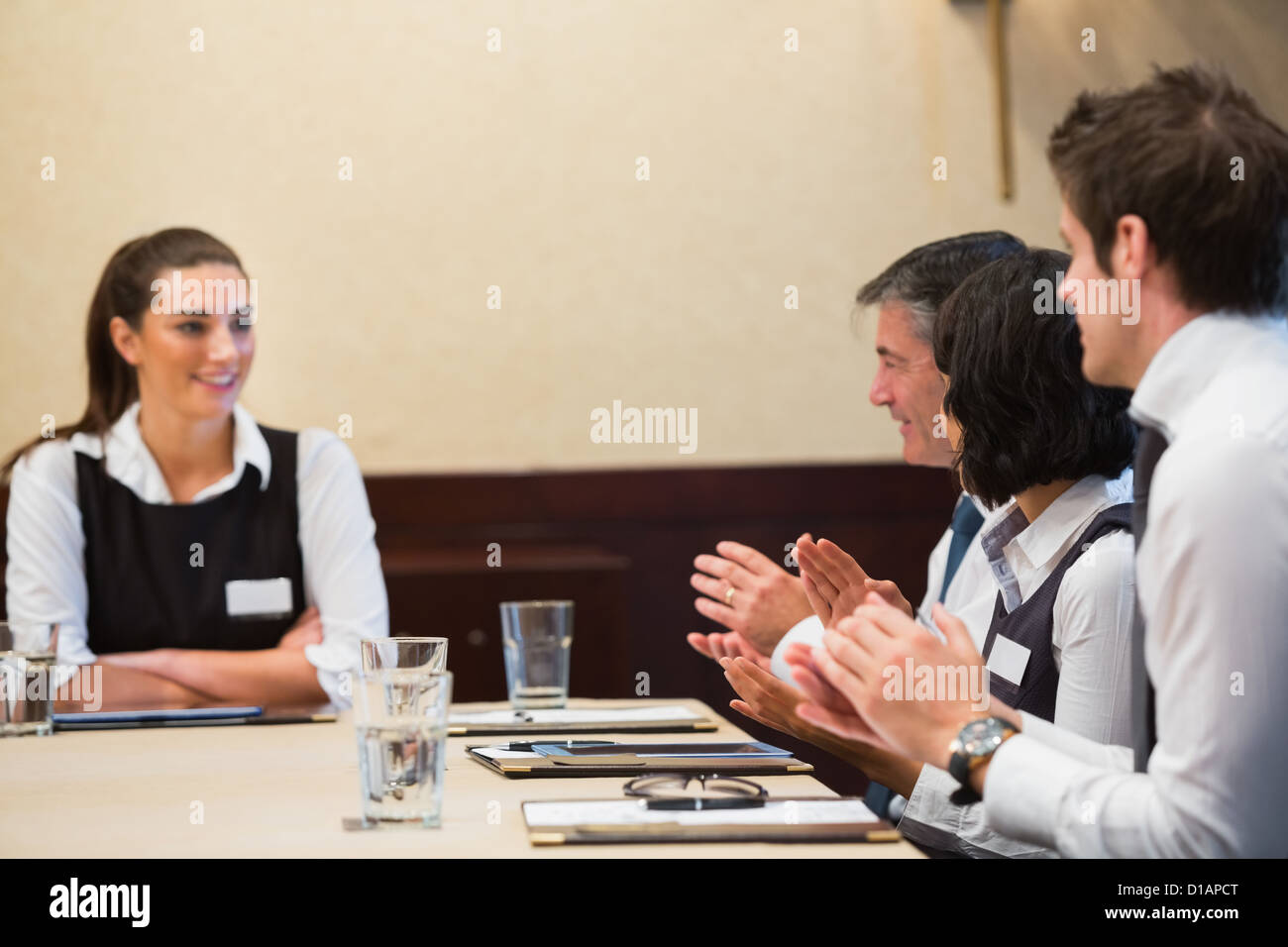 Business people clapping colleague Stock Photo - Alamy