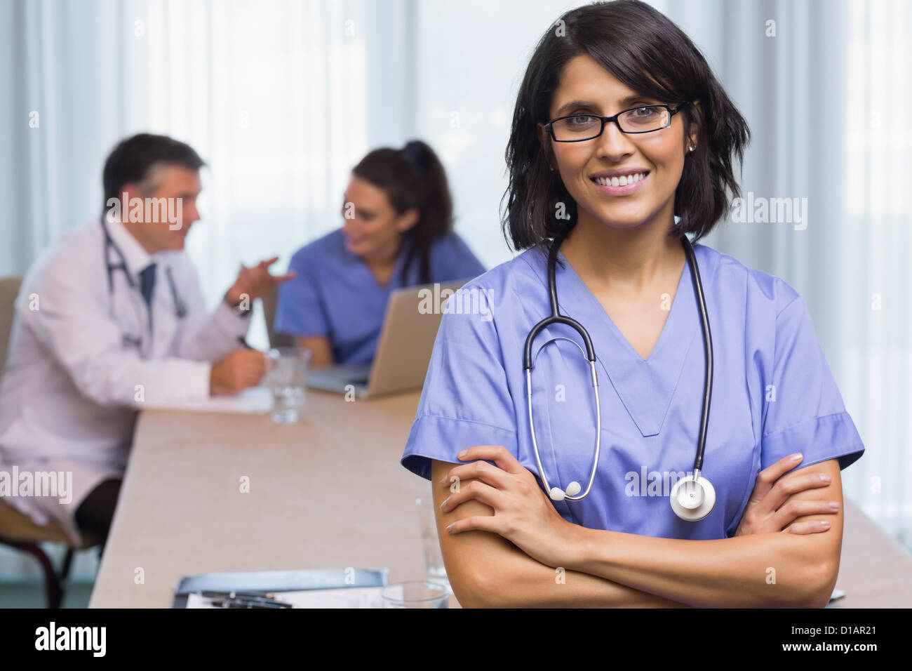 Smiling nurse with arms crossed Stock Photo - Alamy