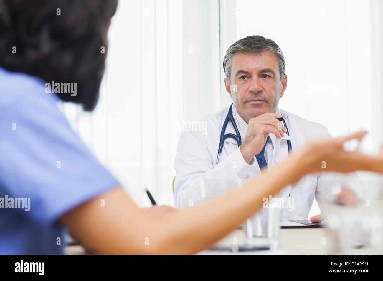 Doctor listening to nurse Stock Photo - Alamy