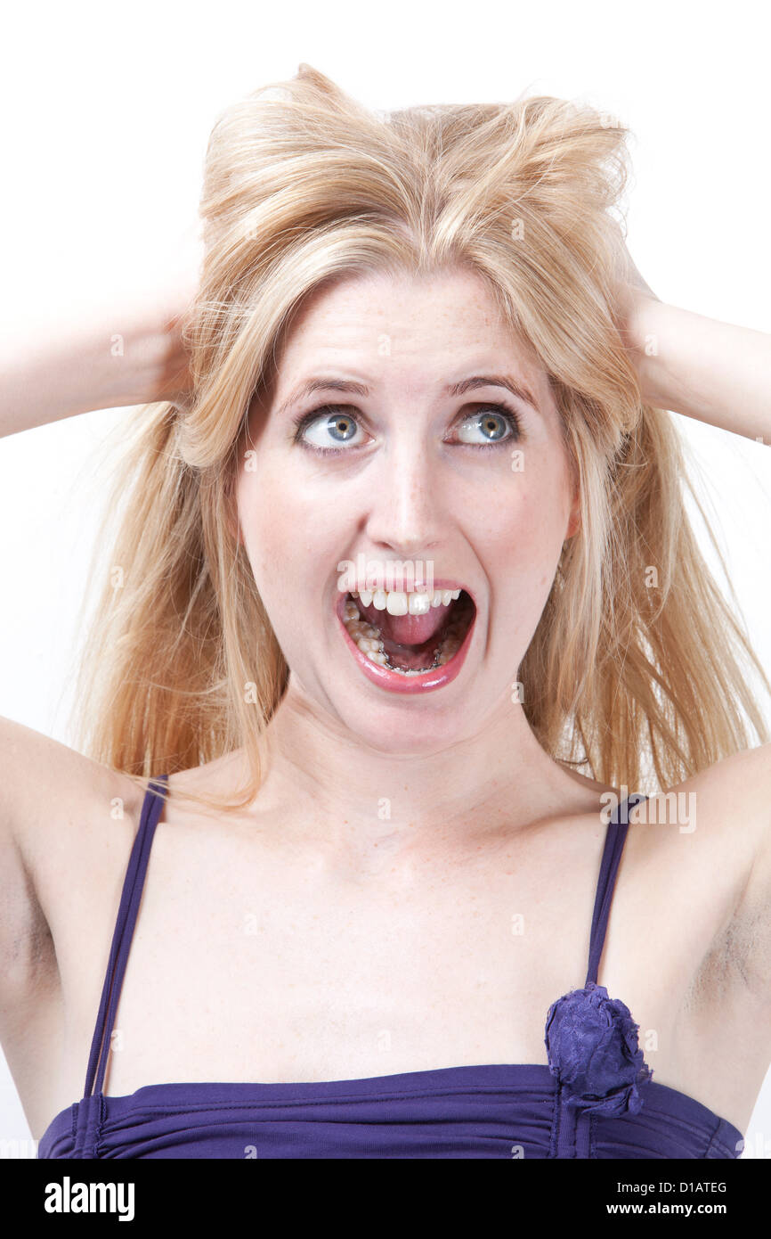 Angry young woman hands in hair screaming Stock Photo - Alamy