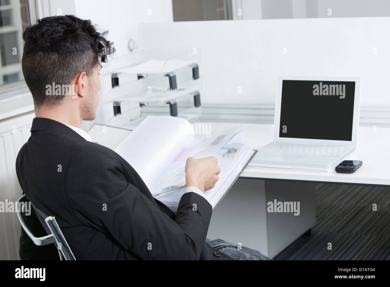 Rear view young businessman working at office Stock Photo - Alamy