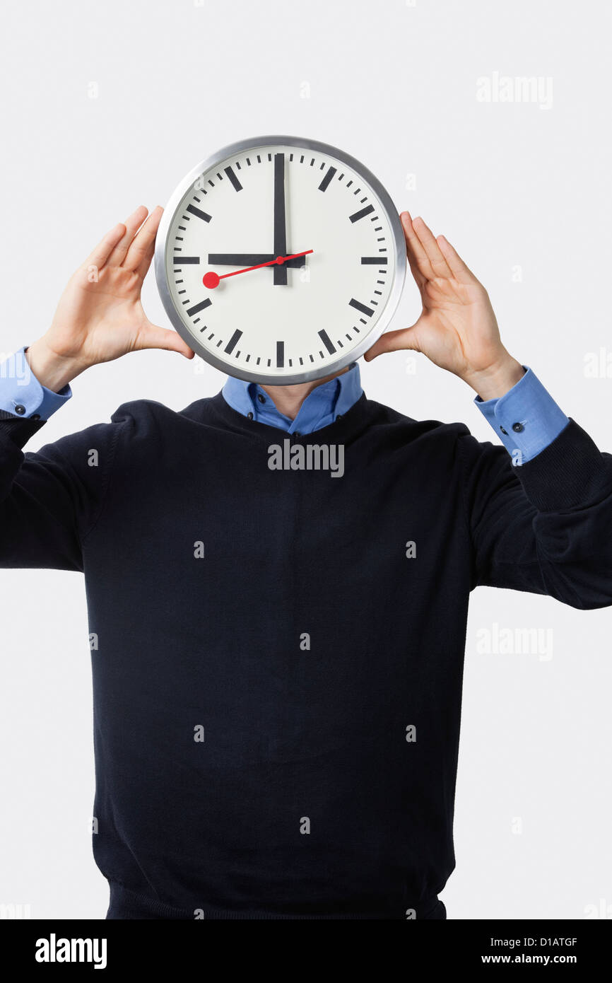 Young man covering his face clock sitting Stock Photo - Alamy