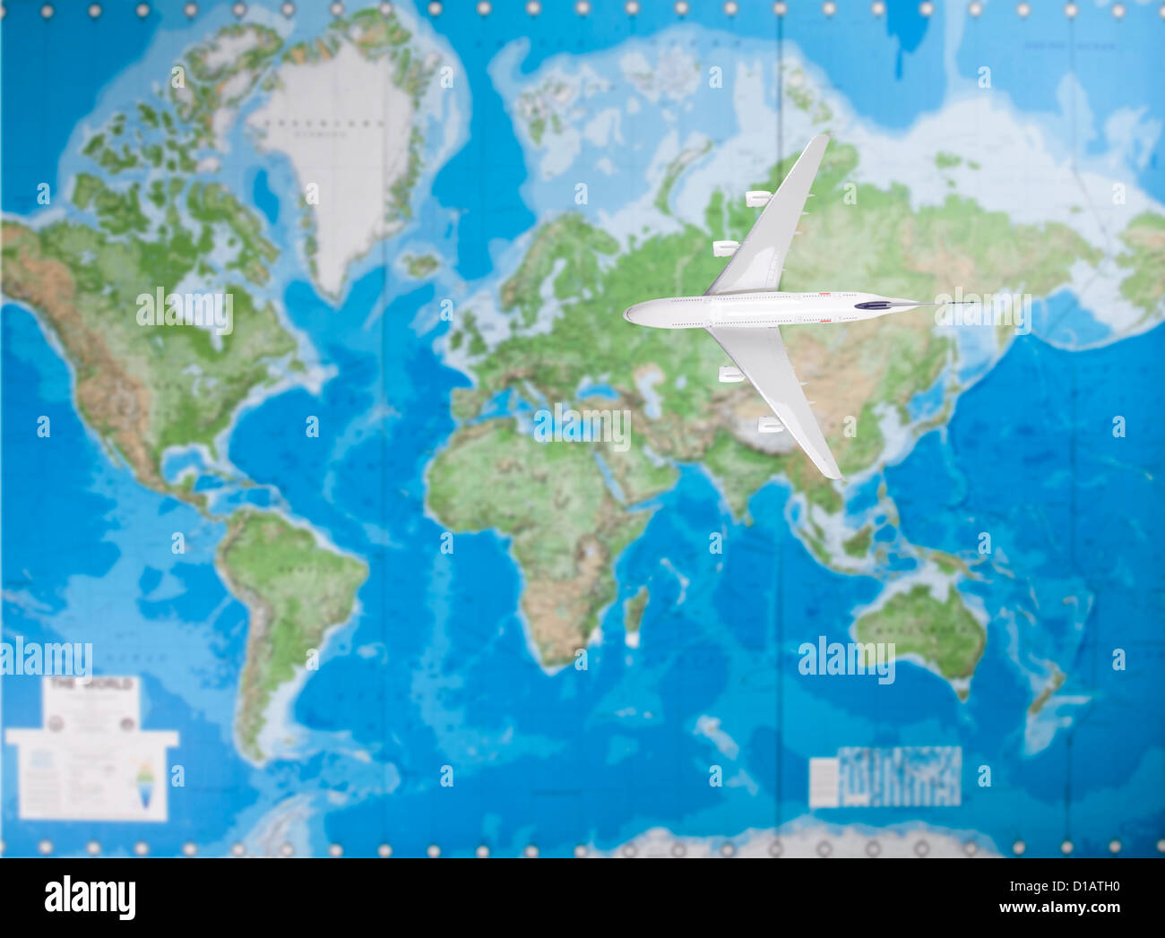 Model airplane flying over world map Stock Photo - Alamy