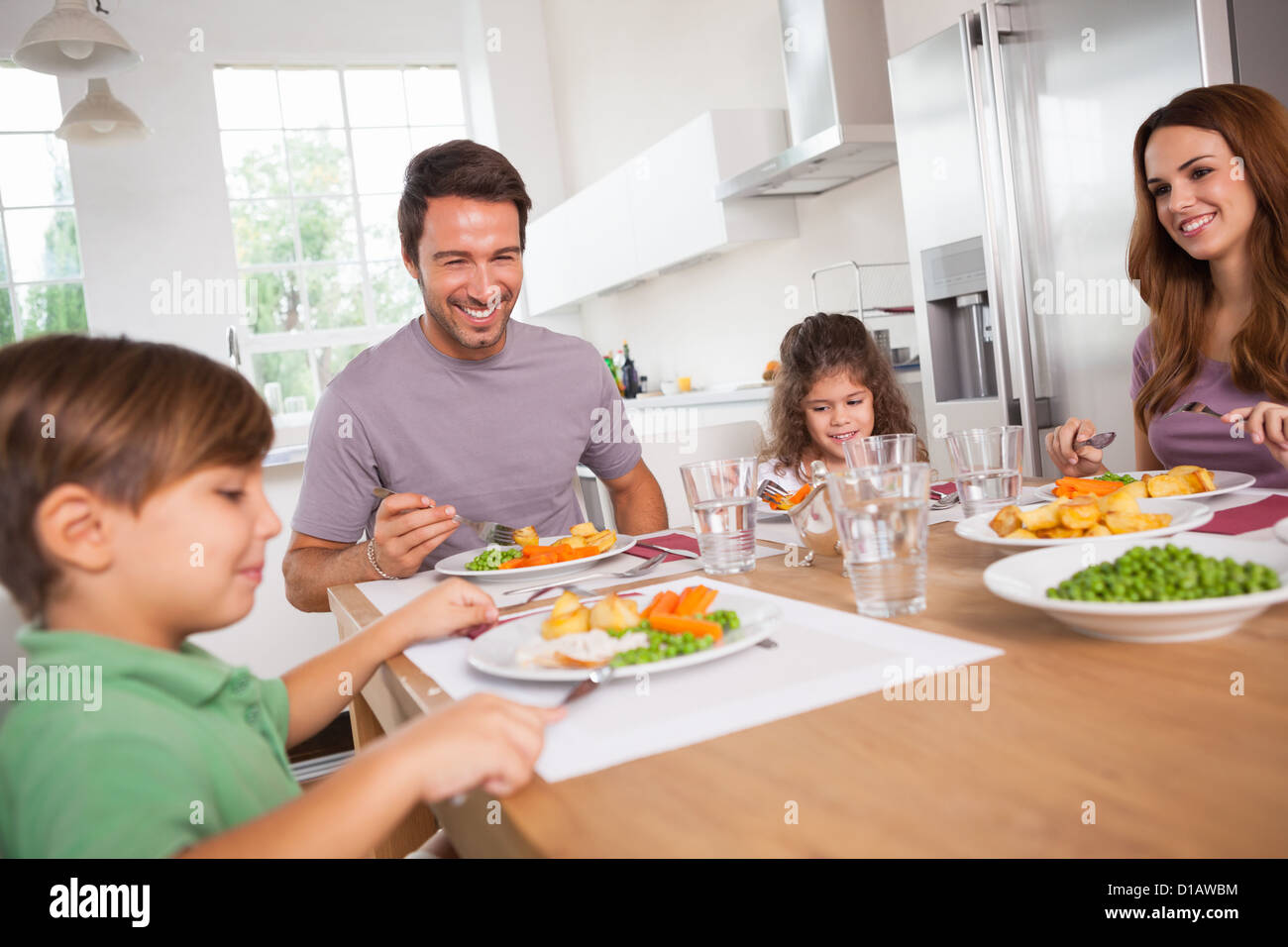 Family smiling around a good meal Stock Photo - Alamy