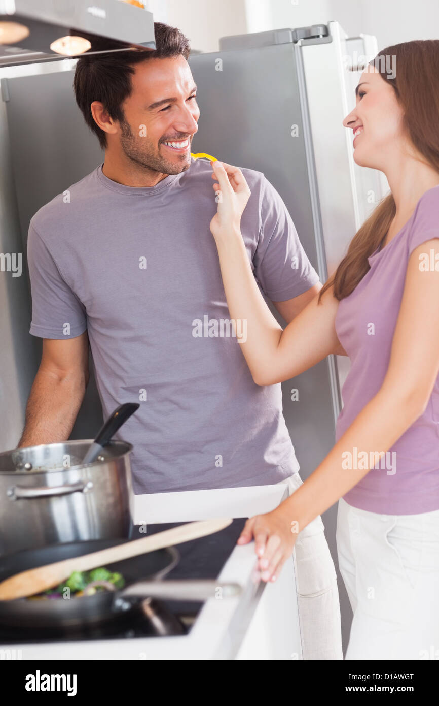 Woman feeding man with a yellow pepper Stock Photo - Alamy