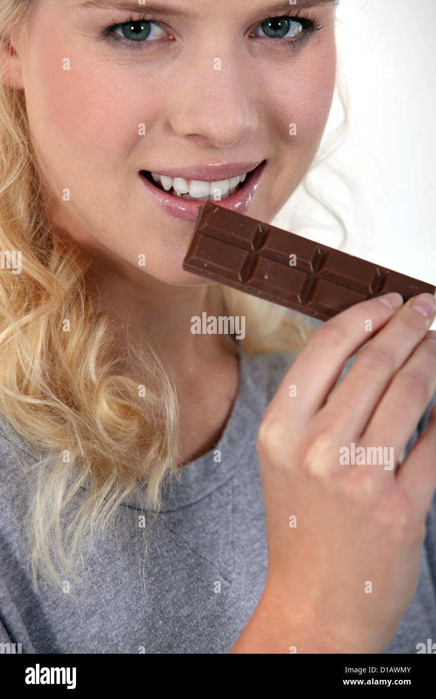 Woman eating chocolate Stock Photo - Alamy