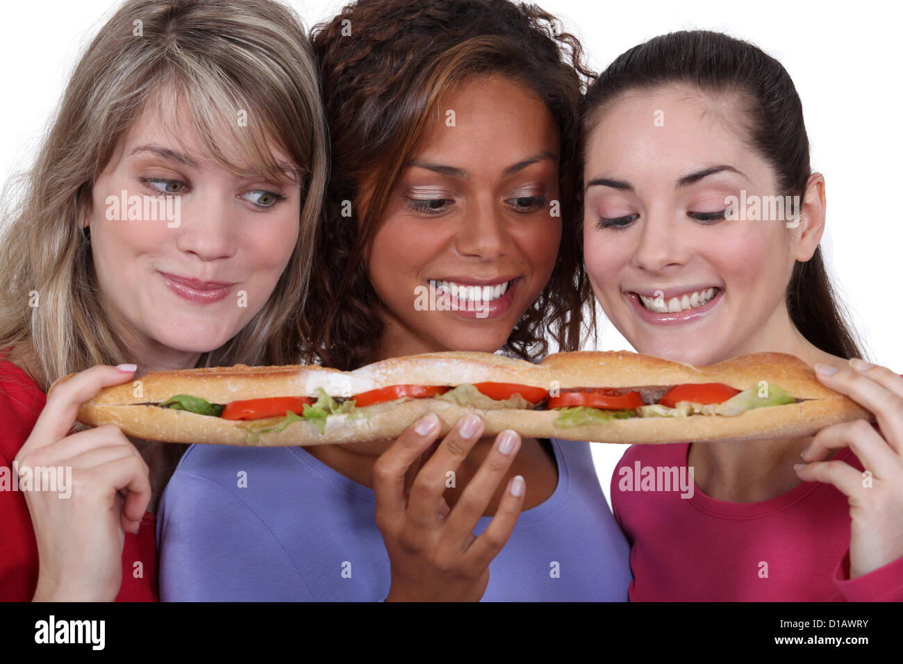 Three female friends sharing long sandwich Stock Photo - Alamy