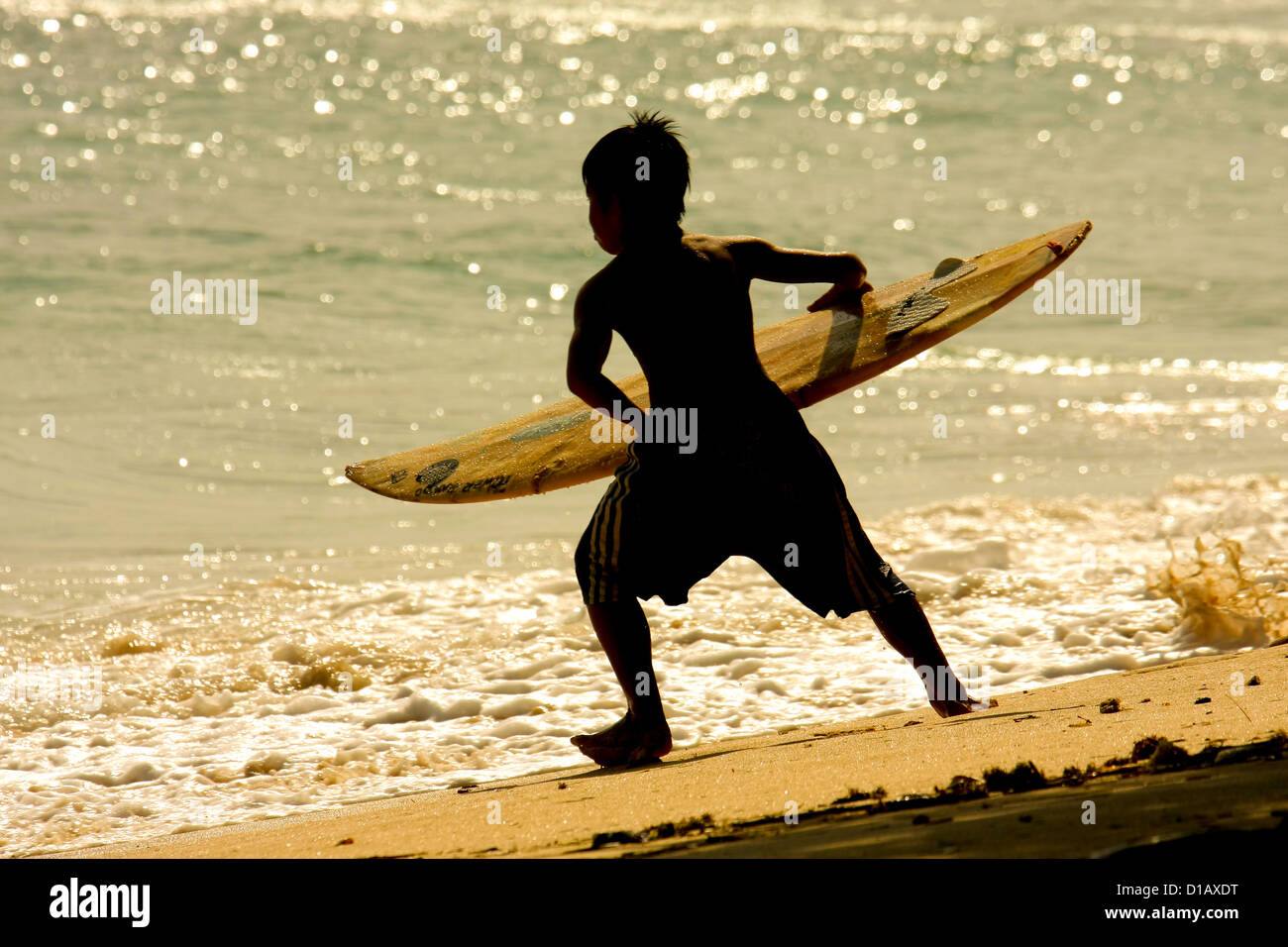 Indonesian Kid surfing in Bali Stock Photo - Alamy