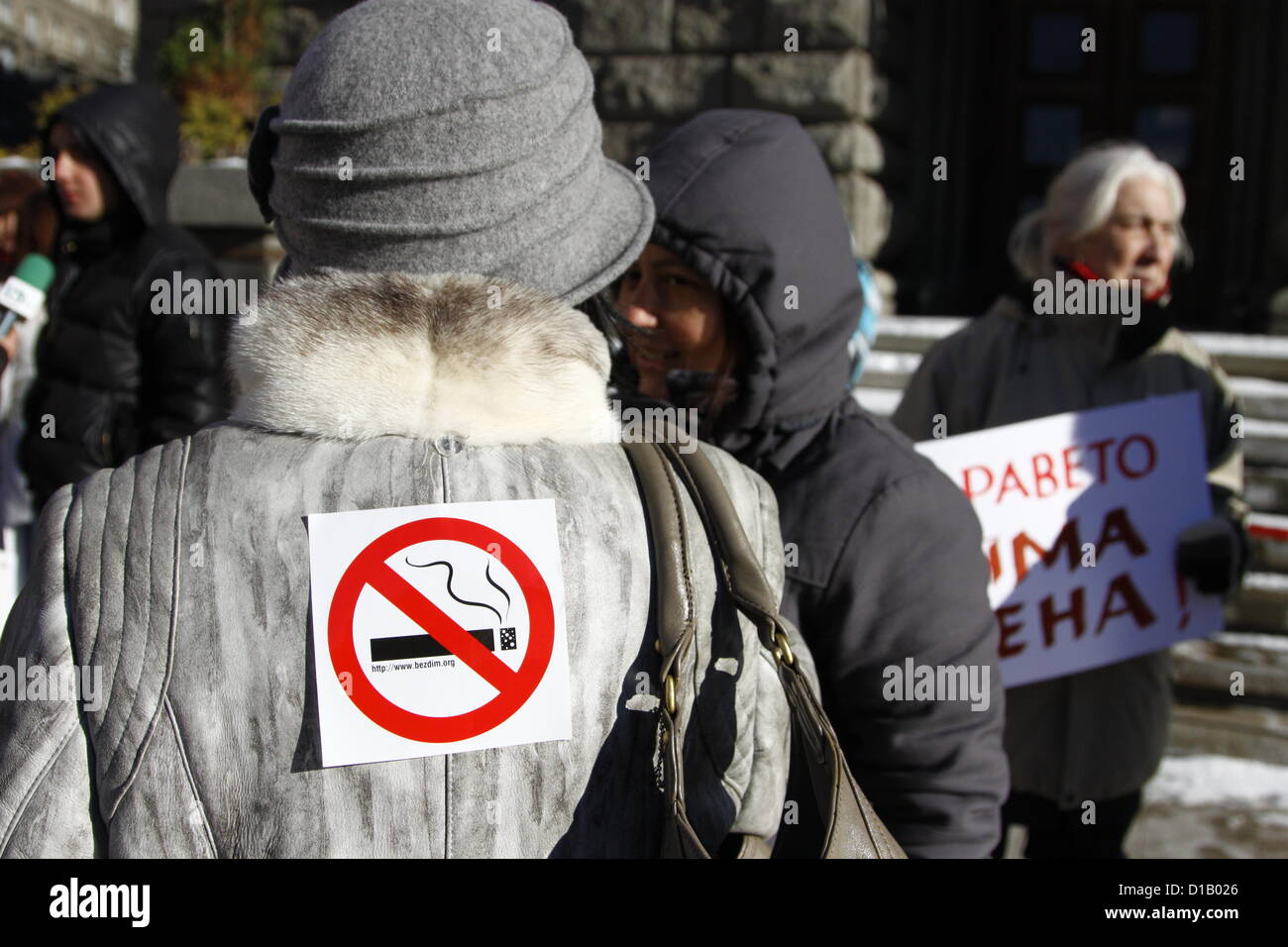 Demonstrator wearing a no smoking sign on the back of her coat. The ...